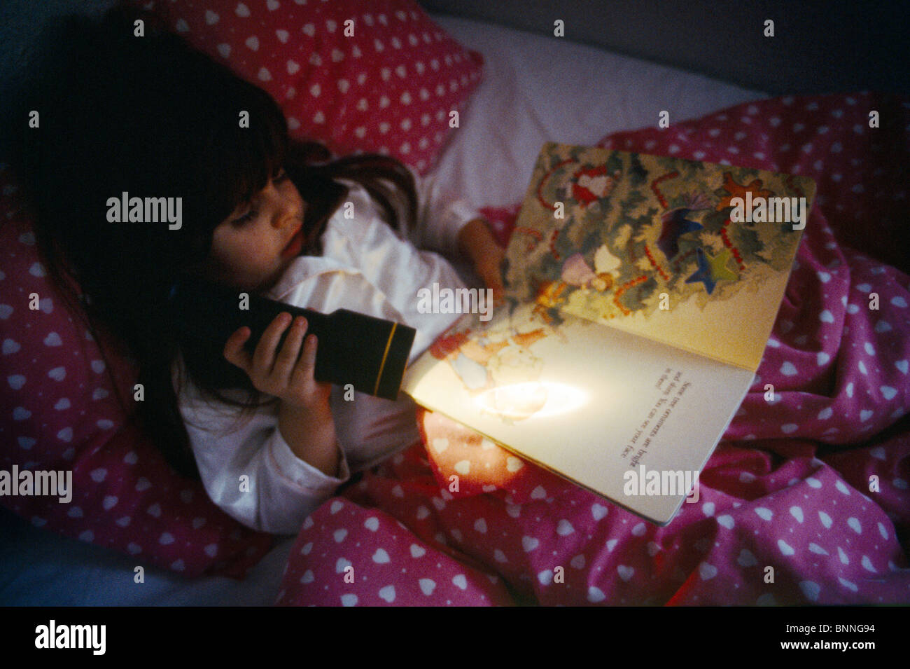 Child Using Torch In Bed Stock Photo - Alamy
