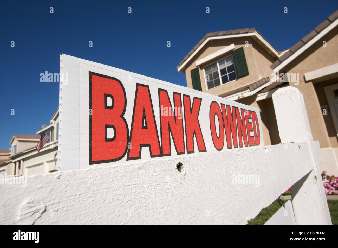 Bank Owned Real Estate Sign and House with American Flag in the ...