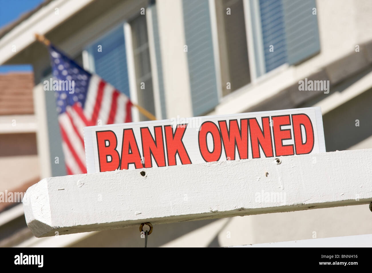 Bank Owned Real Estate Sign and House with American Flag in the ...