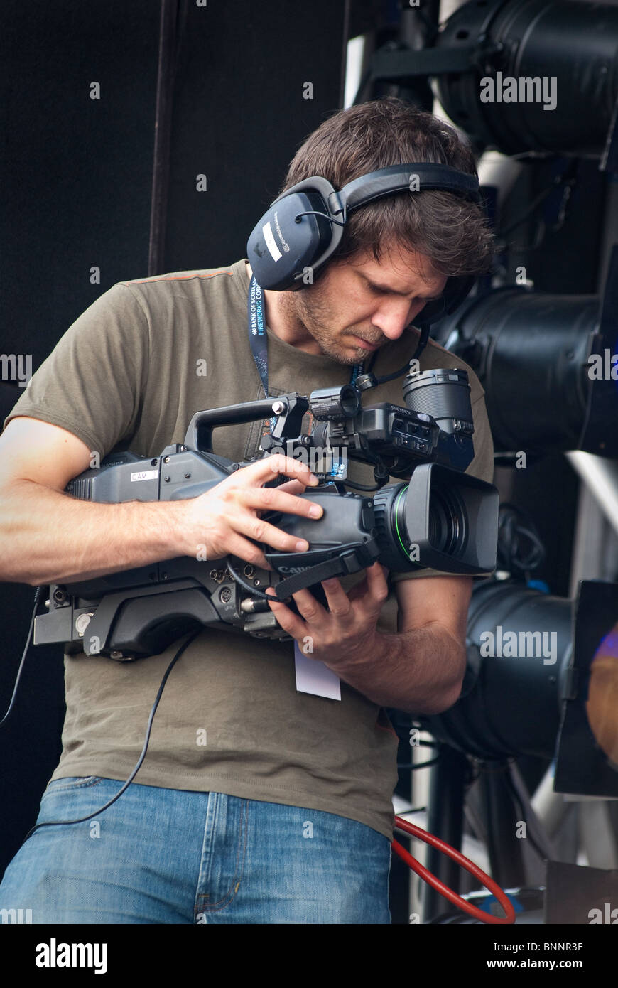 Video camera operator recording live event, hand held camera ...