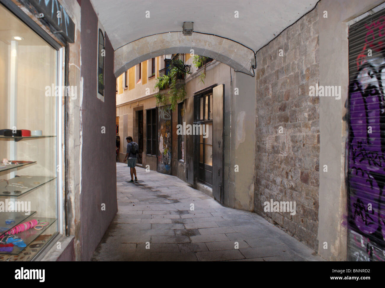 PERSON STROLLING DOWN AN ALLEY IN THE GOTHIC QUARTER OF BARCELONA SPAIN ...