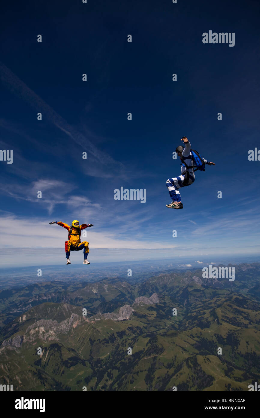 Skydivers are flying head up within a team in the sit fly position over ...