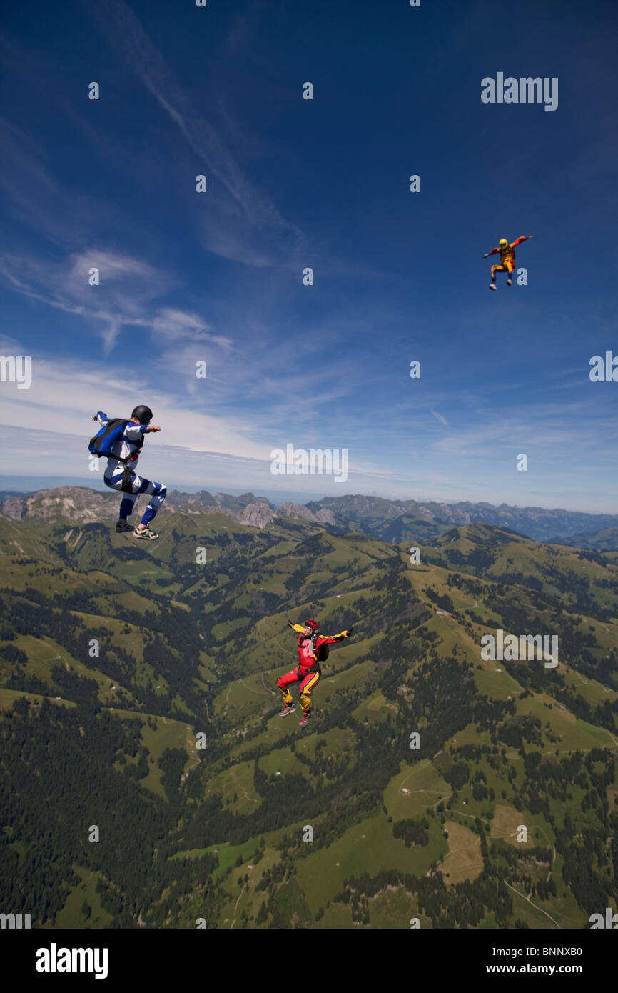 Skydivers are flying head up within a team in the sit fly position over ...