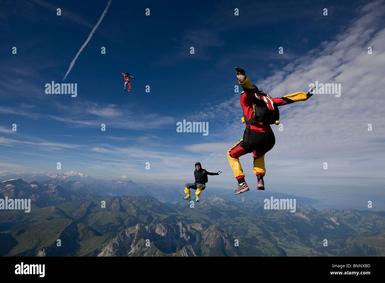 Skydivers are flying head up within a team in the sit fly position over ...