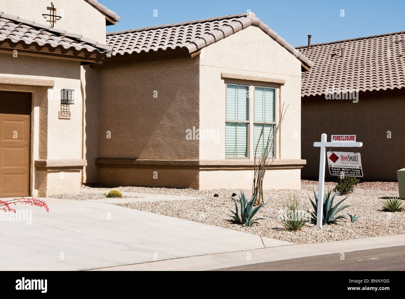 A foreclosed house has a for sale sign in the front yard Stock Photo ...