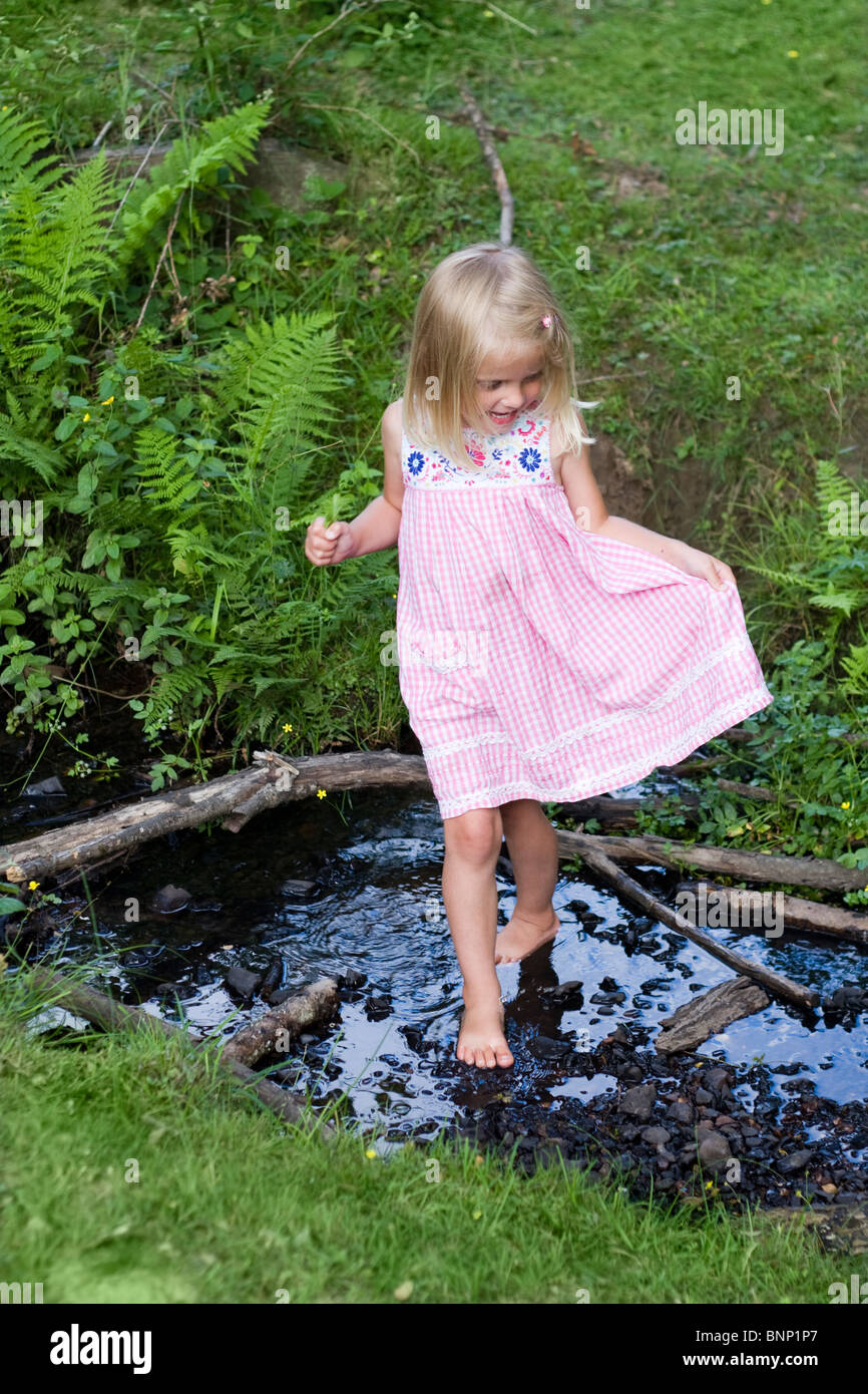 Young girl paddling in woodland stream Stock Photo - Alamy