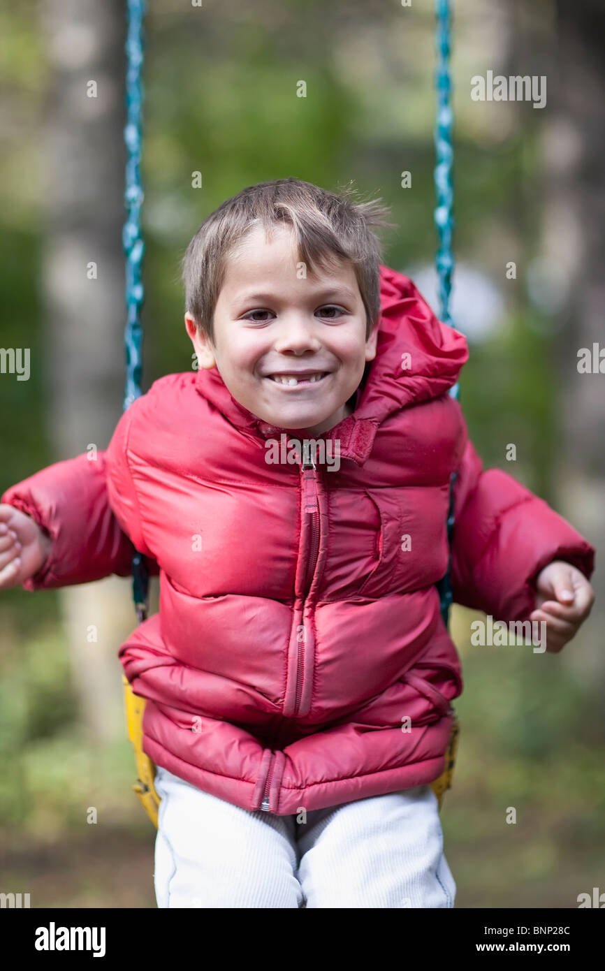 Five year old boy playing on a swing Stock Photo - Alamy