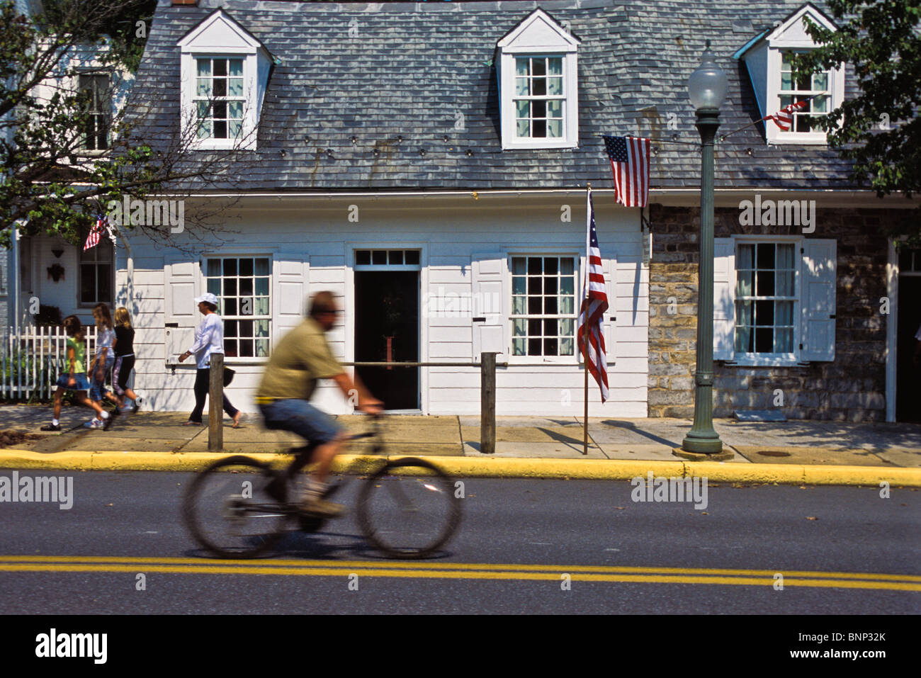 Green energy, man riding bicycle in small town stret Stock Photo - Alamy
