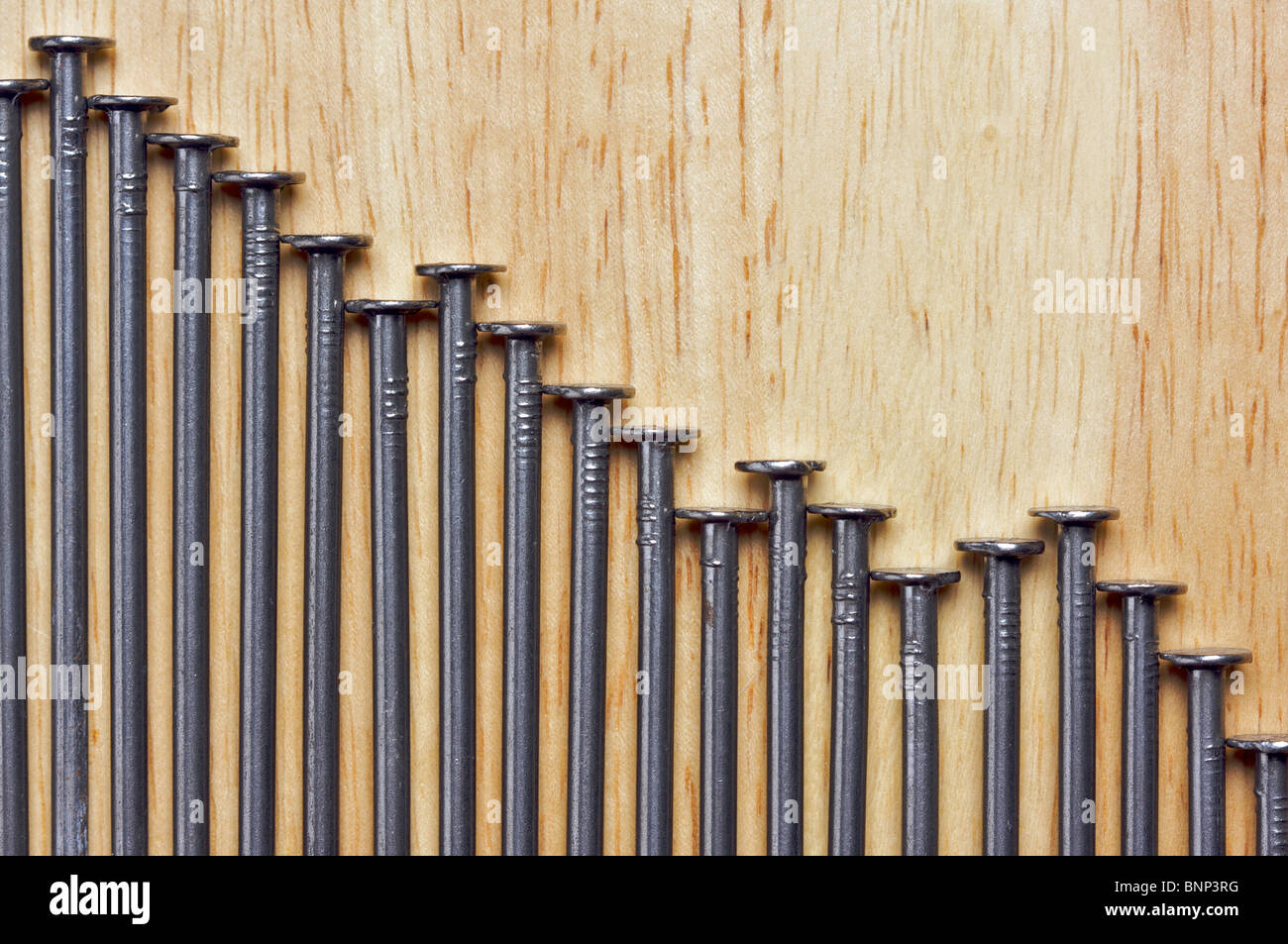Declining Graph of Nails on a Wood Background Stock Photo - Alamy