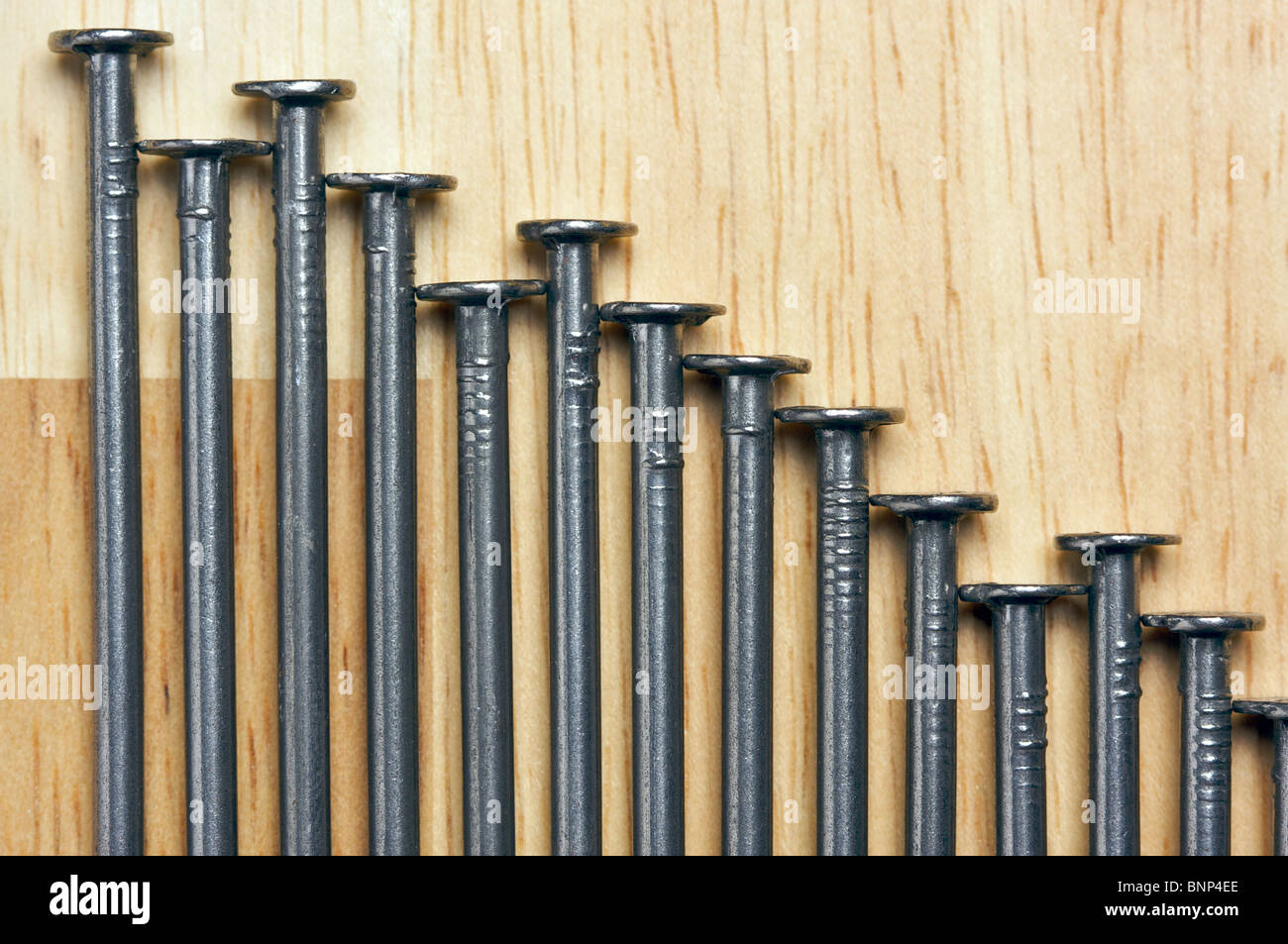Declining Graph of Nails on a Wood Background Stock Photo - Alamy
