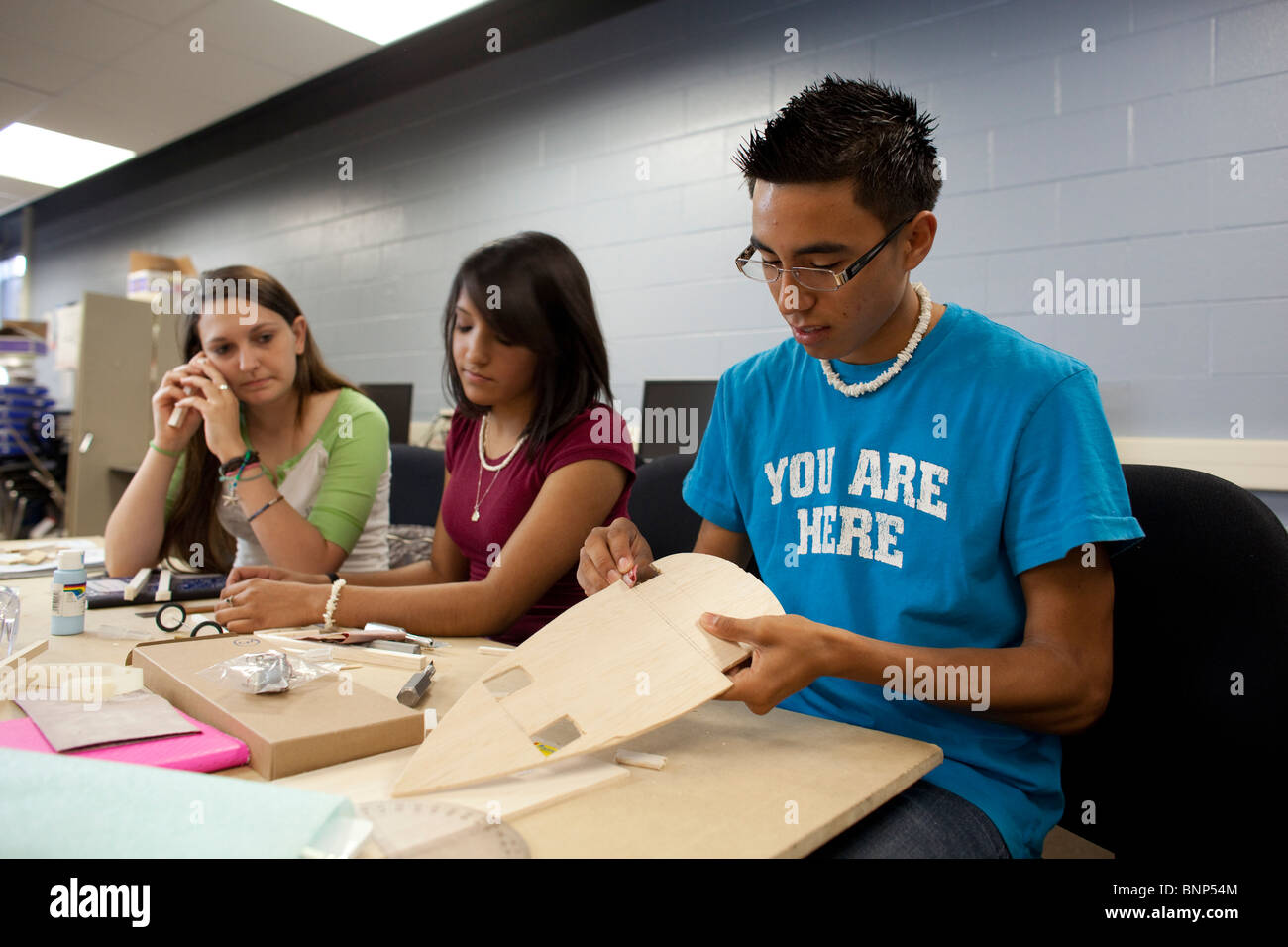 Male and female students work as a team to design and build a model ...