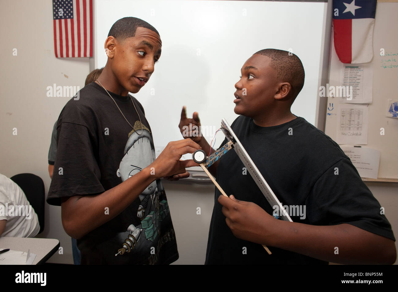 African-American boys discuss their model solar-powered car in ...