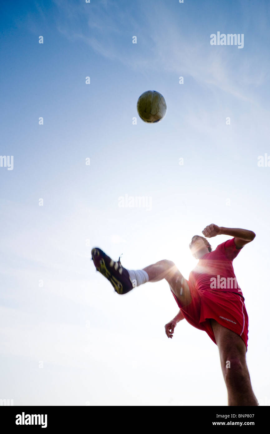 Soccer player kicking ball Stock Photo - Alamy