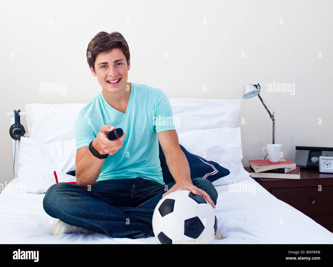 Teen guy watching a football match in television Stock Photo - Alamy