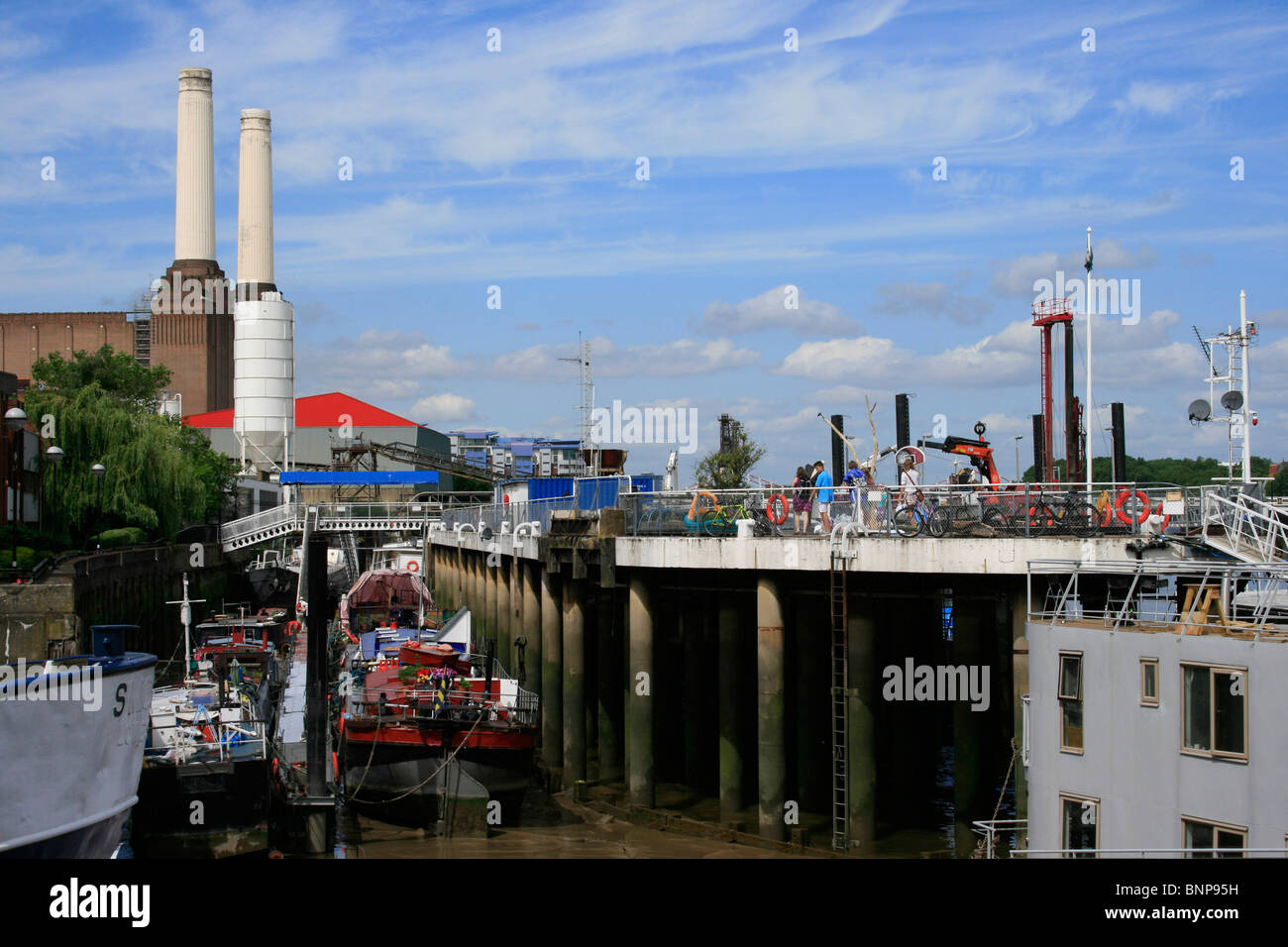 Boats and barges in Tideway Village with Battersea Power Station in the ...