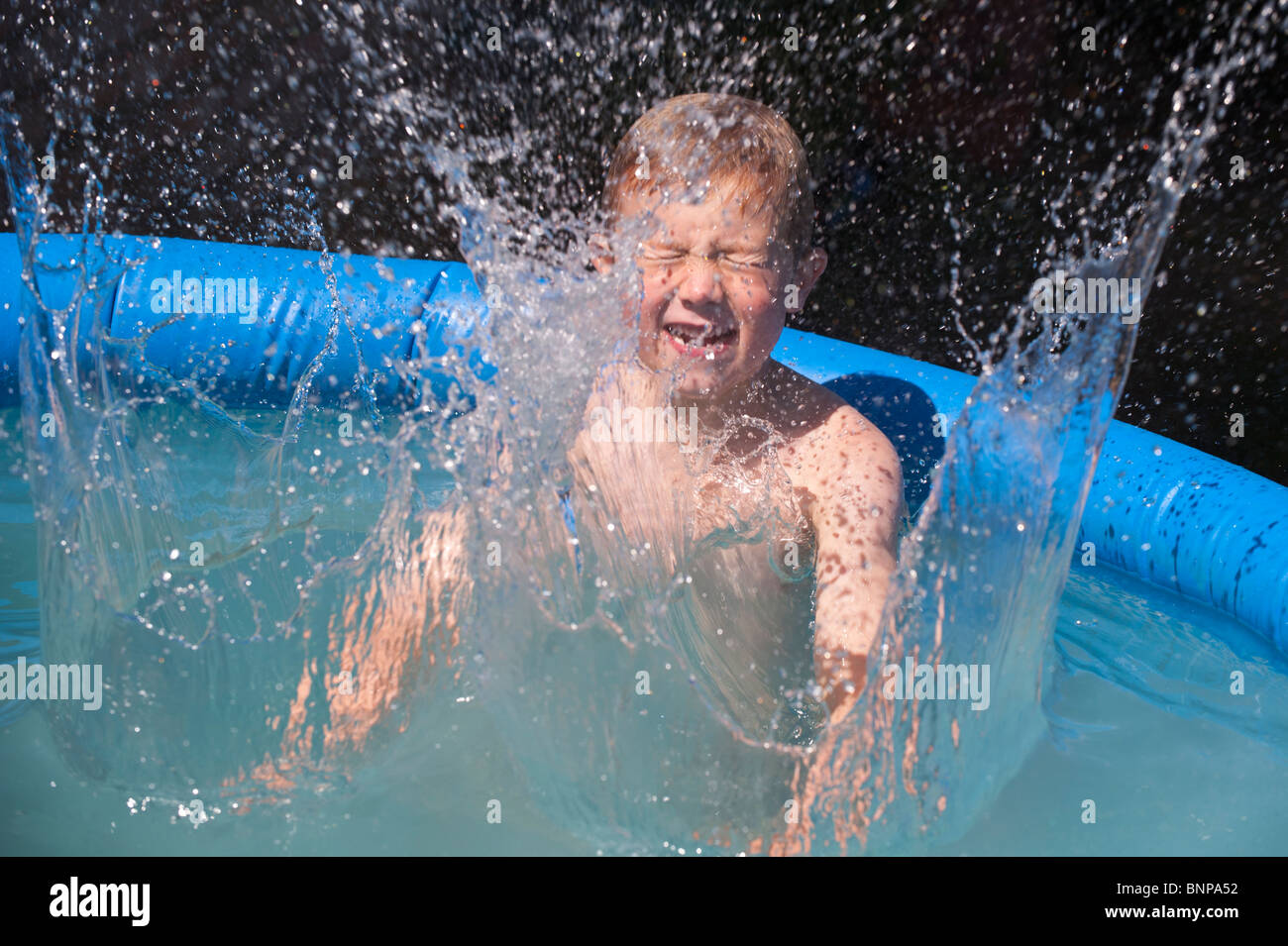 A MODEL RELEASED six year old boy splashing and showing movement in a ...