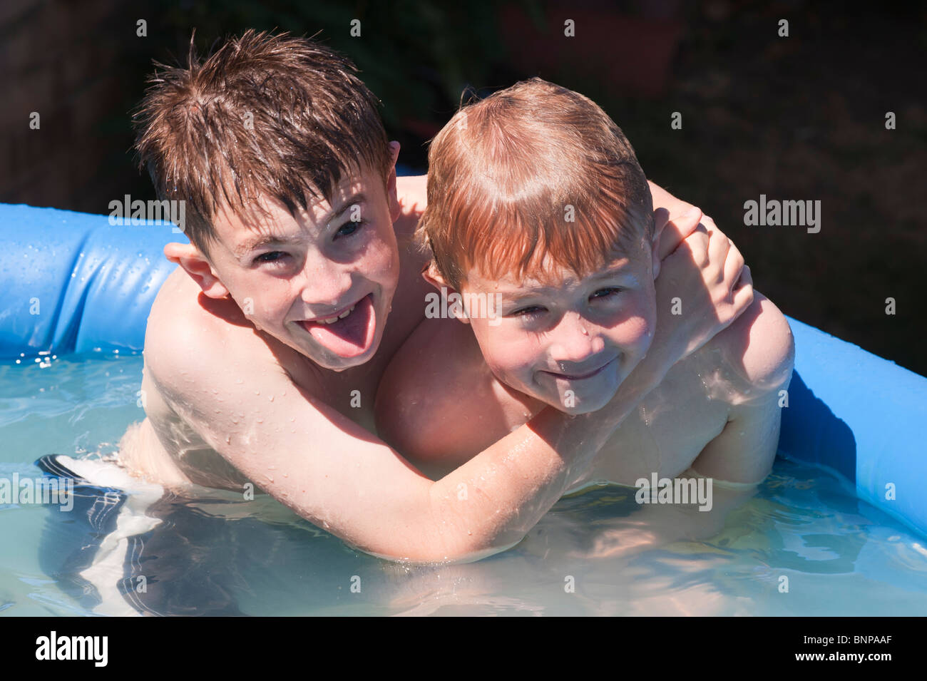 A MODEL RELEASED photo of two boys ( 6 & 10 ) in a small garden ...