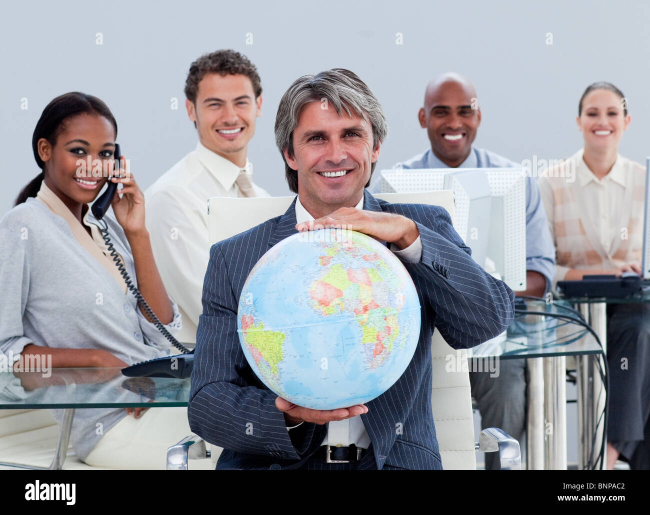 Fortunate business team at work showing a terrestrial globe Stock Photo ...