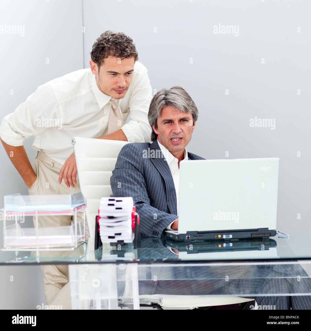 Confident manager helping his colleague work at a computer Stock Photo ...