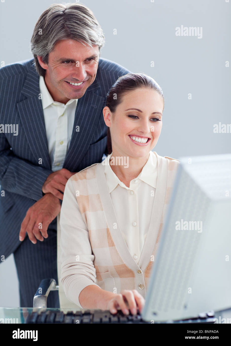 Manager helping his colleague work at a computer Stock Photo - Alamy