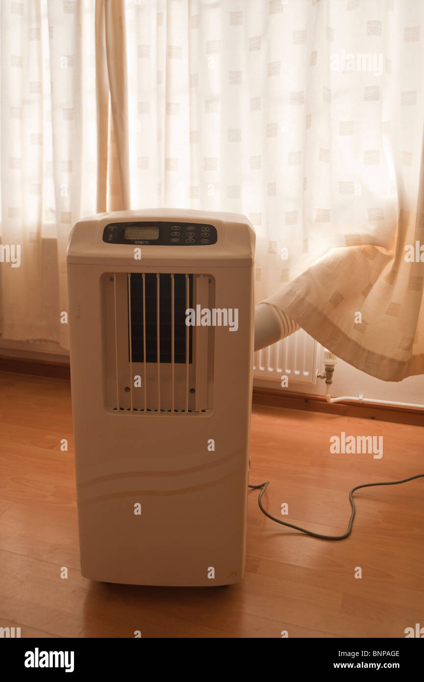 A portable air conditioning unit in use indoors showing the outlet pipe ...