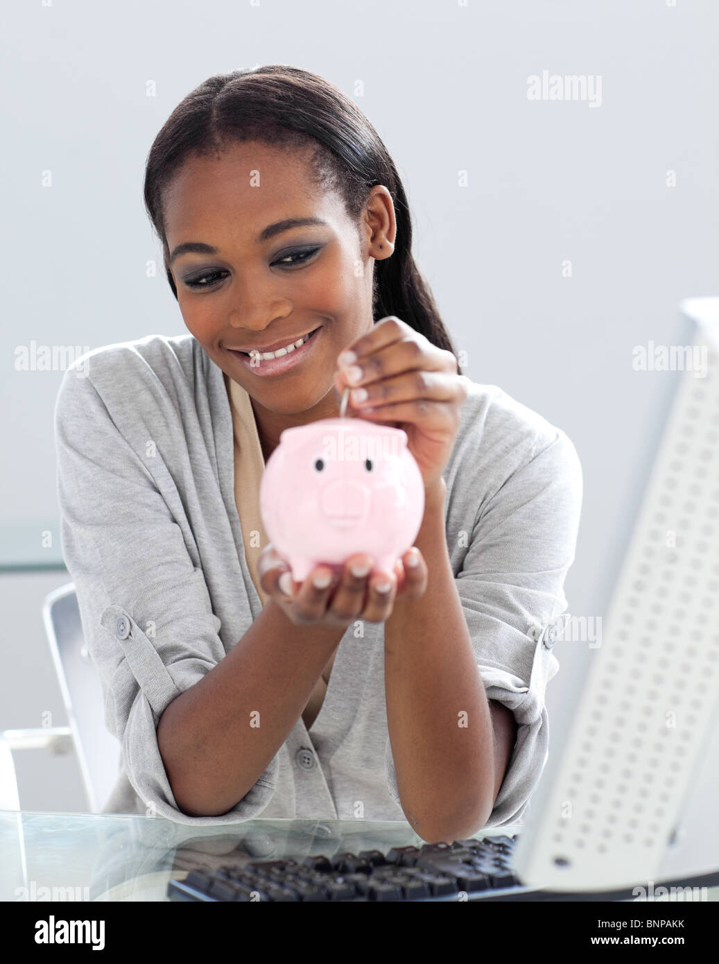 Assertive businesswoman saving money in a piggybank Stock Photo - Alamy