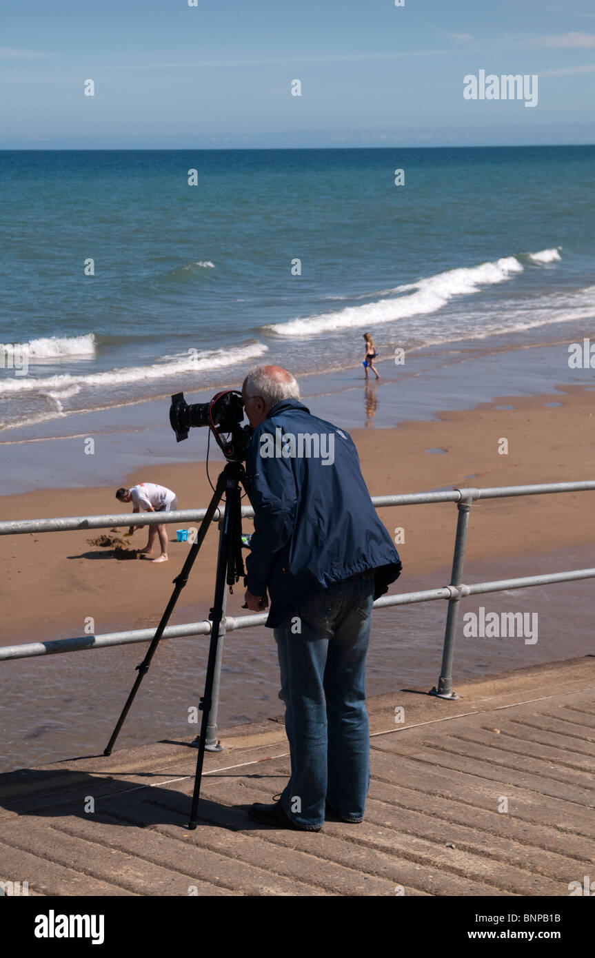 Photographer taking pictures at the coast Norfolk East Anglia England ...