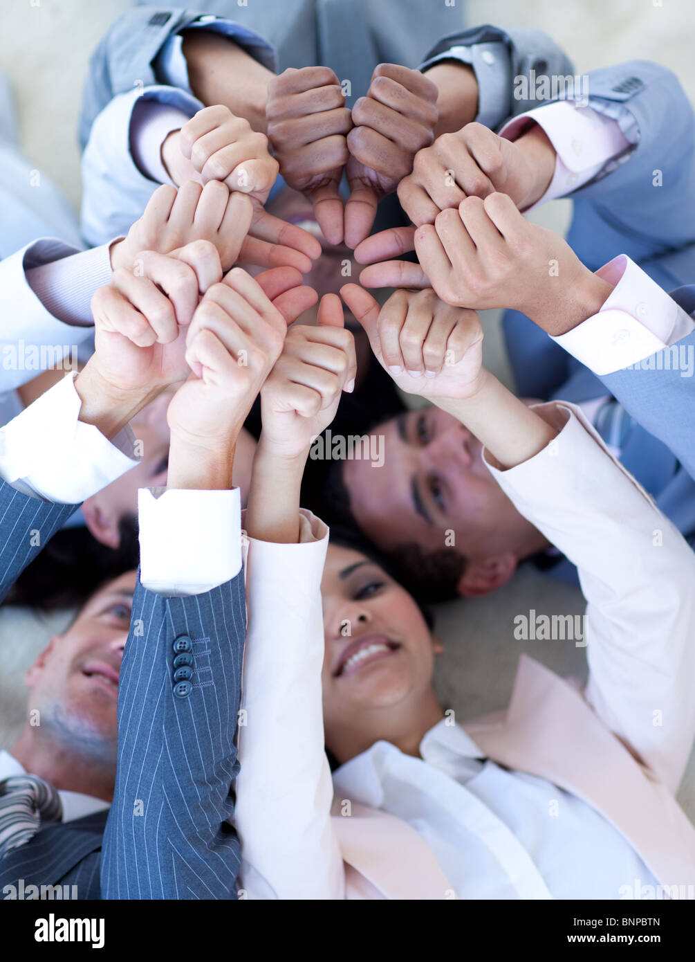 Business team on floor in a circle with thumbs up Stock Photo - Alamy