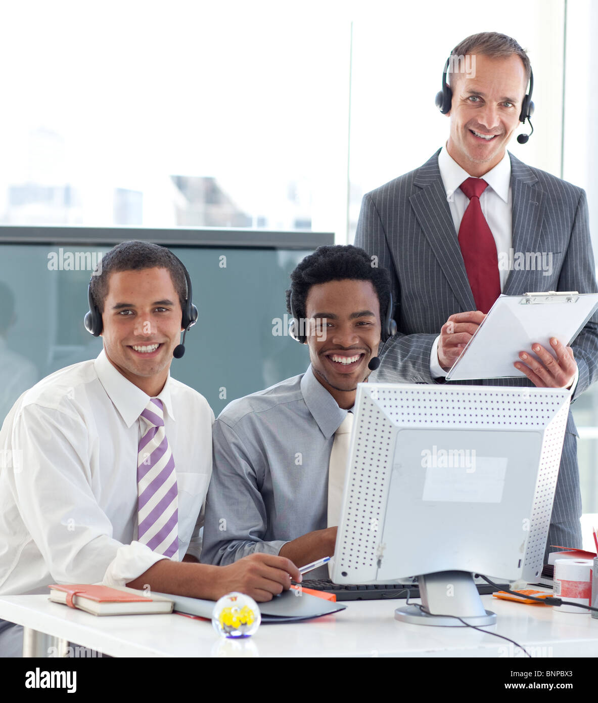Manager talking to two businessmen in call center Stock Photo - Alamy