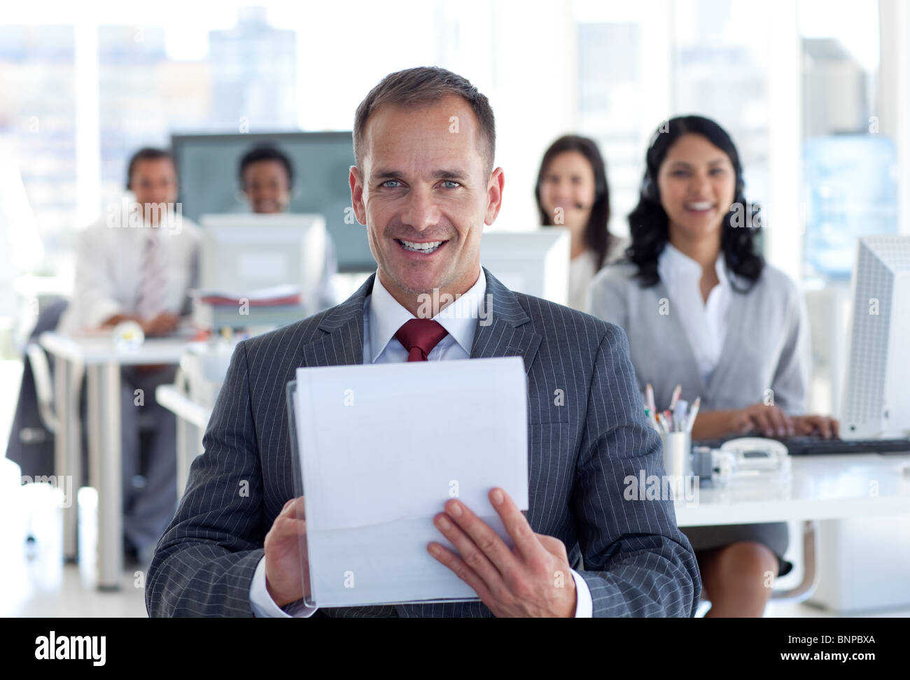 Smiling manager writing notes in a call center Stock Photo - Alamy