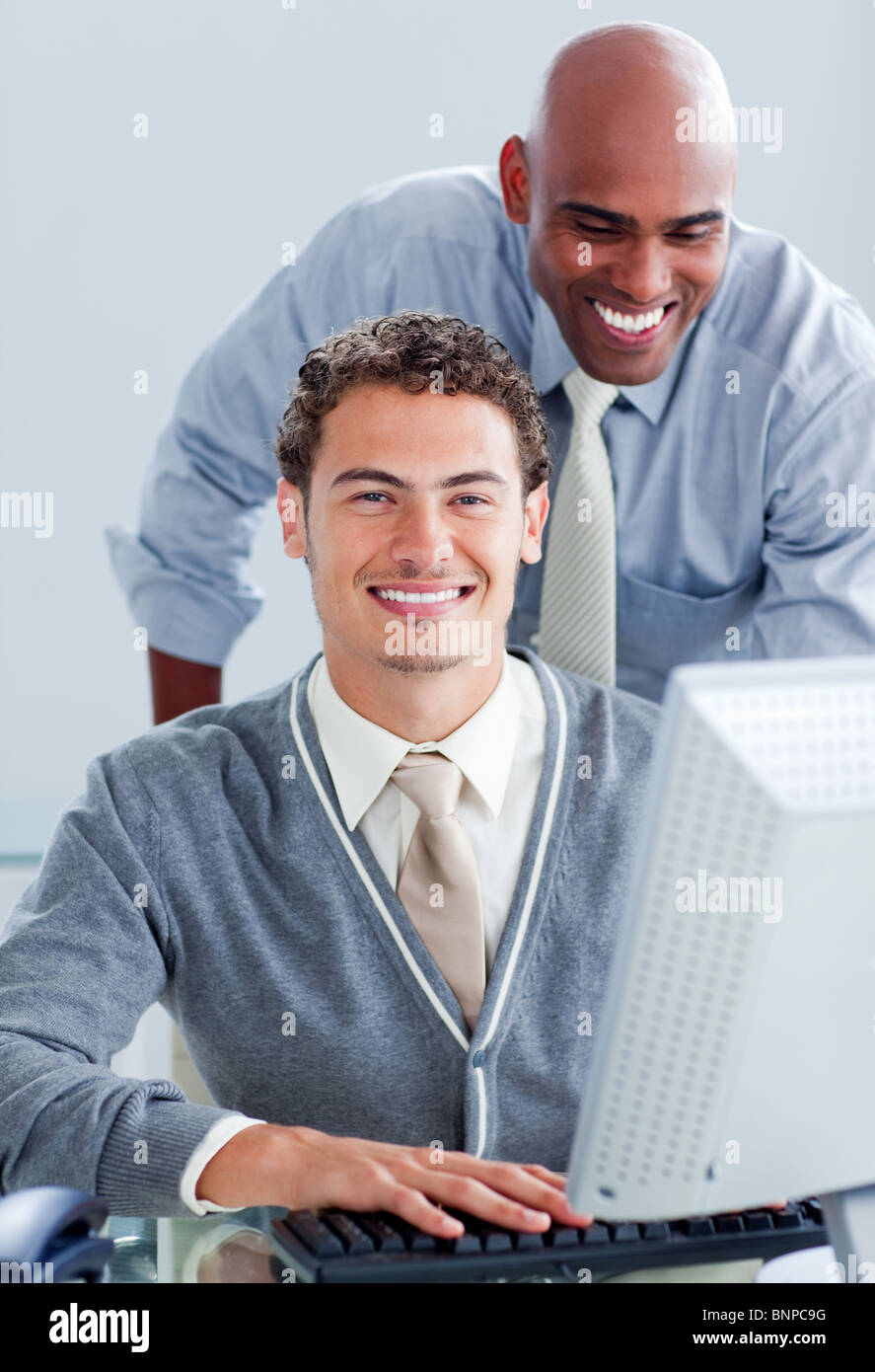 Two attractive businessmen working at a computer Stock Photo - Alamy