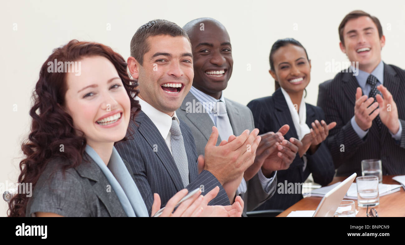 Happy business team laughing and clapping Stock Photo - Alamy