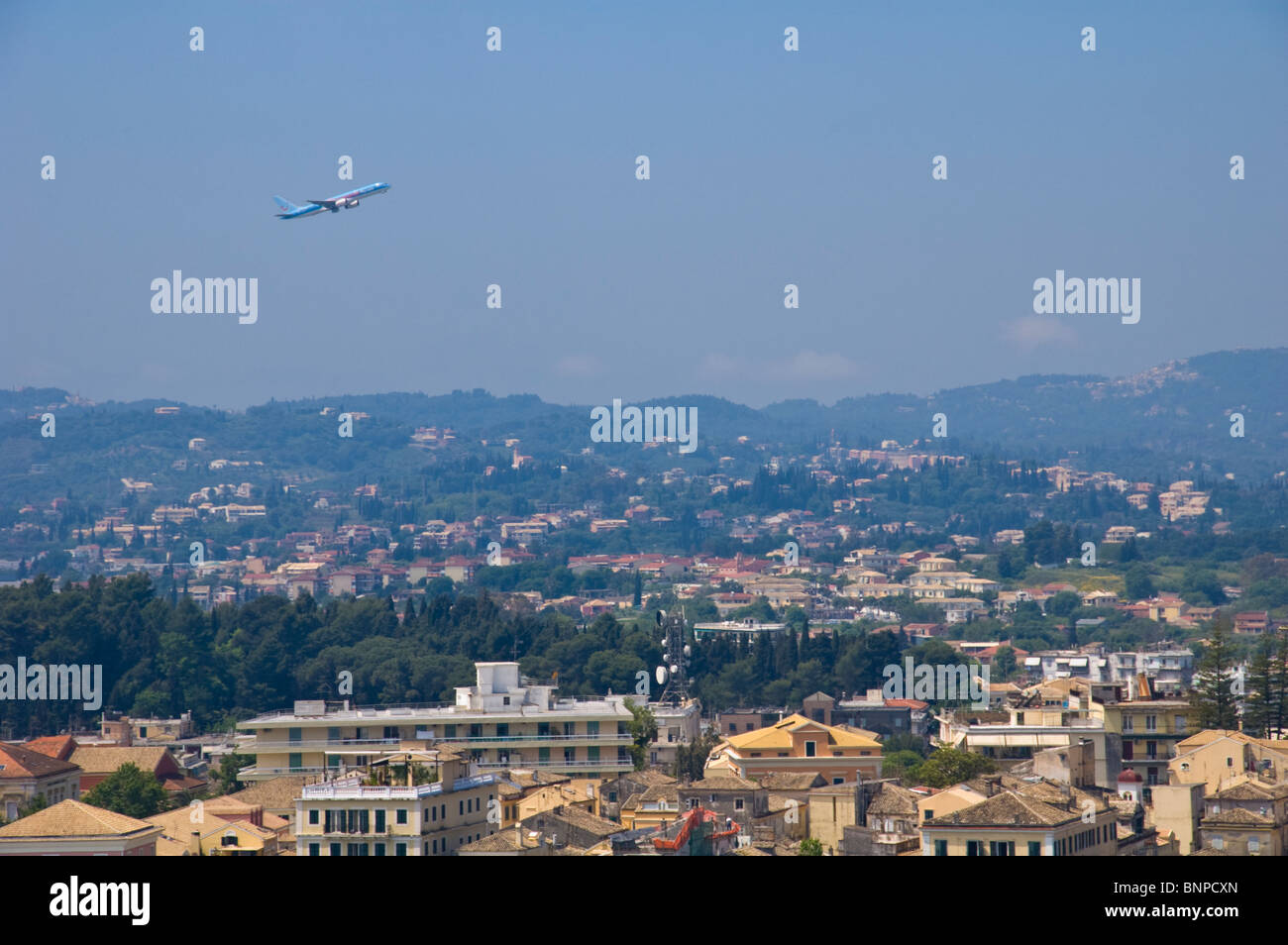Thomson tourist aircraft taking off over Corfu Town on the Greek island ...