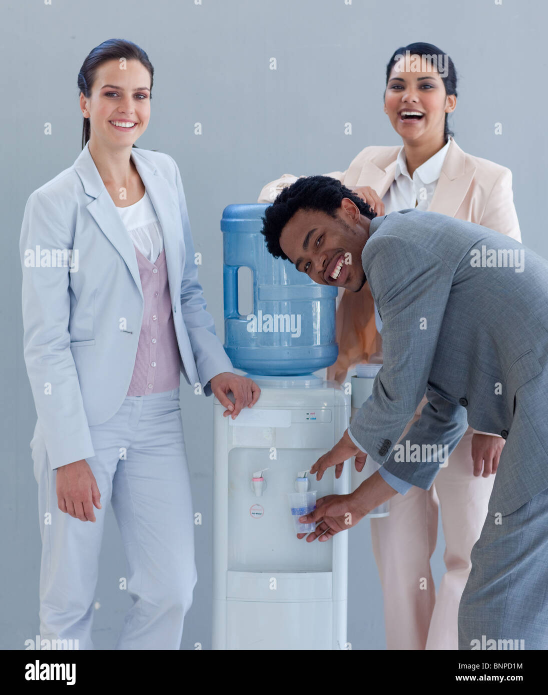 Business team drinking from a water cooler Stock Photo - Alamy