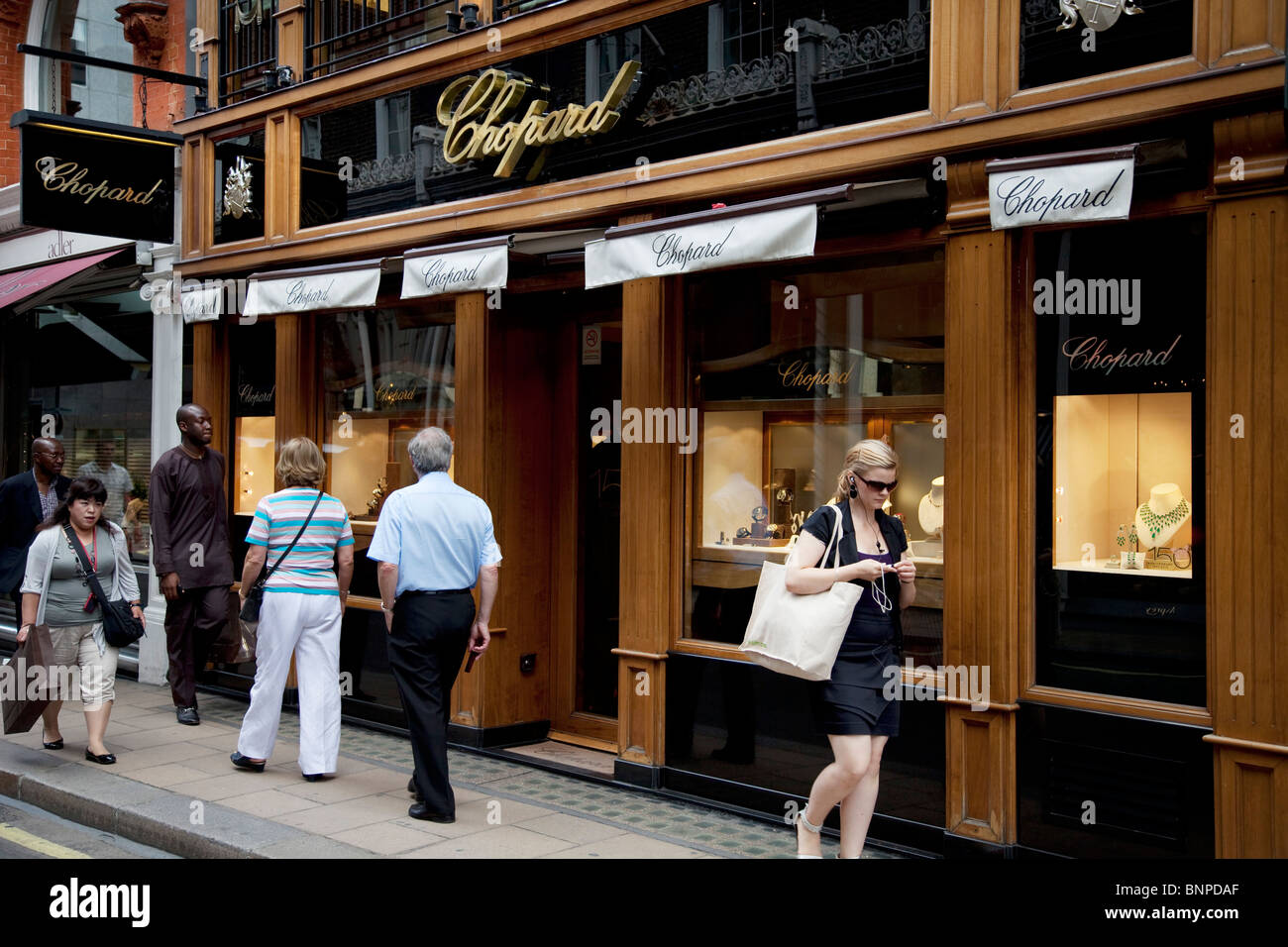 Shoppers pass high end shops on London's Bond Street. Known for it's ...