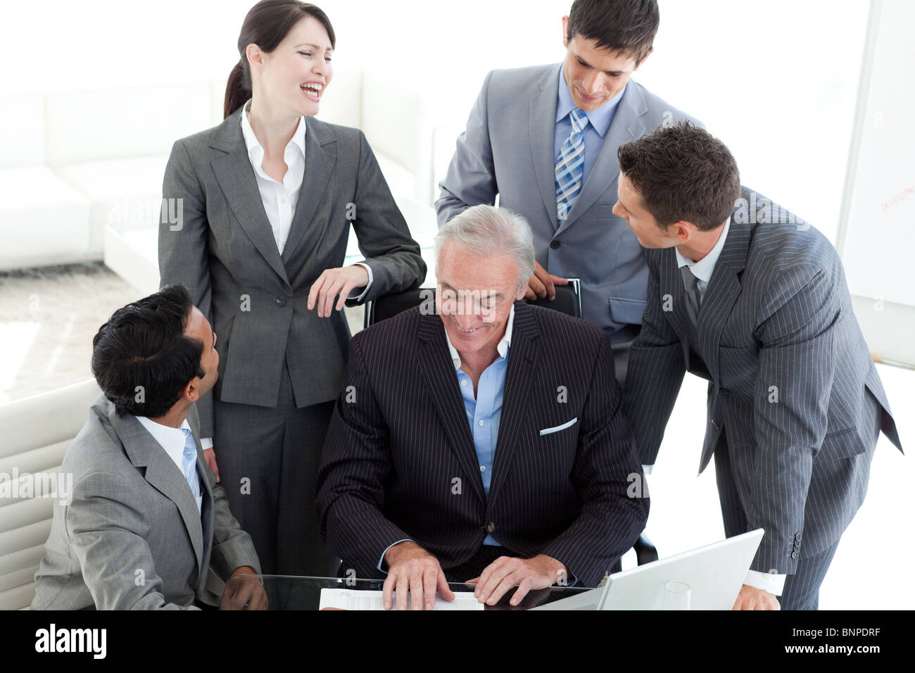 Laughing business team looking at a document with their manager Stock ...