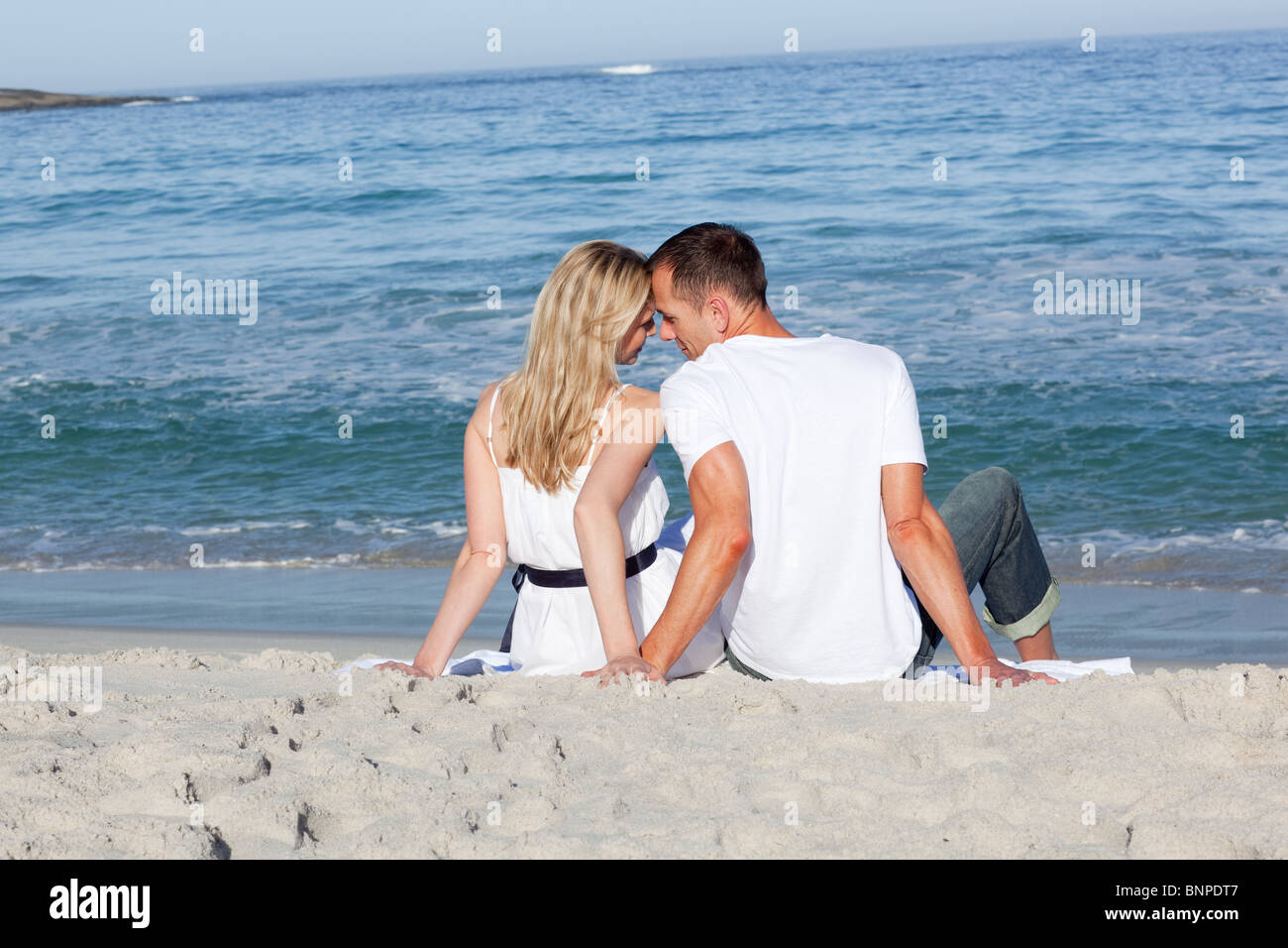 Lovers sitting on the sand Stock Photo - Alamy