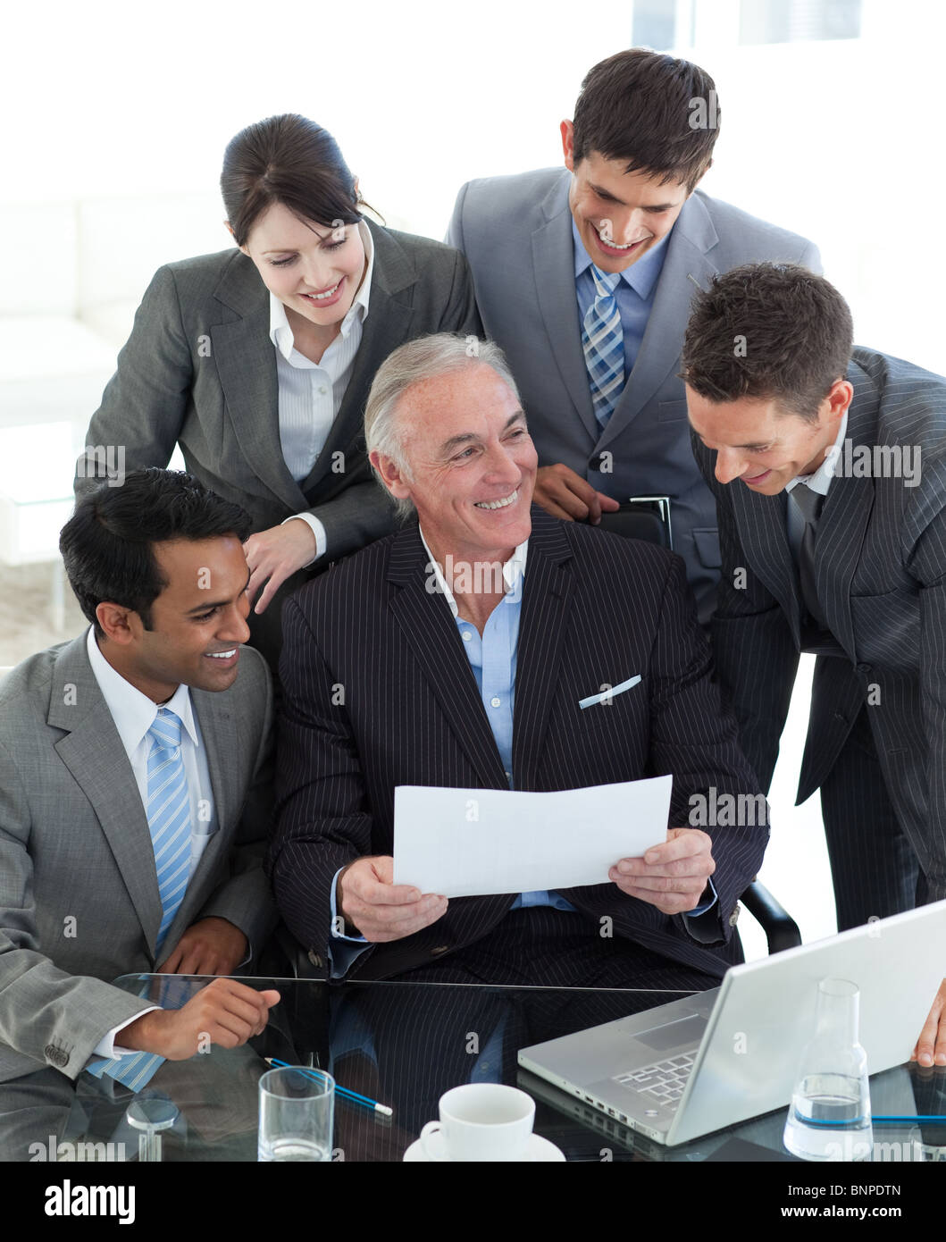 Happy business group studying a document Stock Photo - Alamy