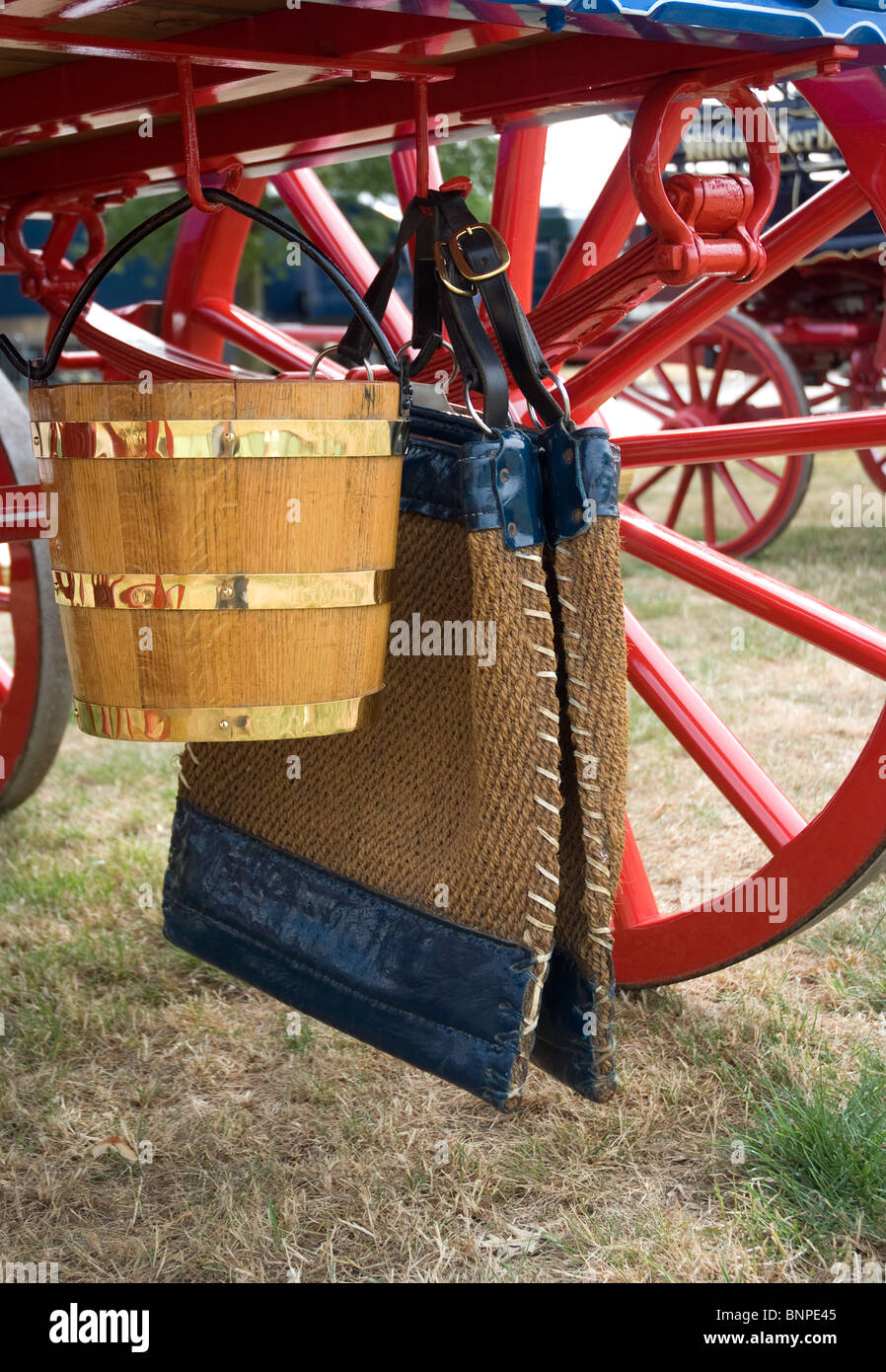 a wooden water bucket and nose bags hanging from a cart Stock Photo - Alamy