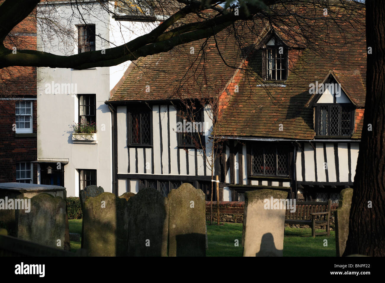 A view of medieval half timbered buildings across a graveyard, Rye ...