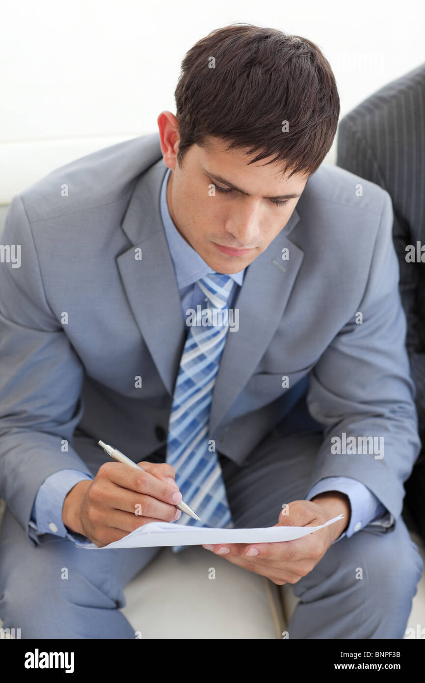 Concentrated businessman writing while waiting for a job interview ...