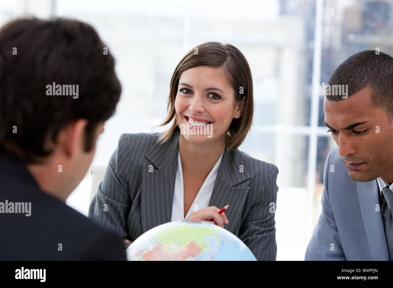 Fortunate Business team looking at a terrestrial globe Stock Photo - Alamy