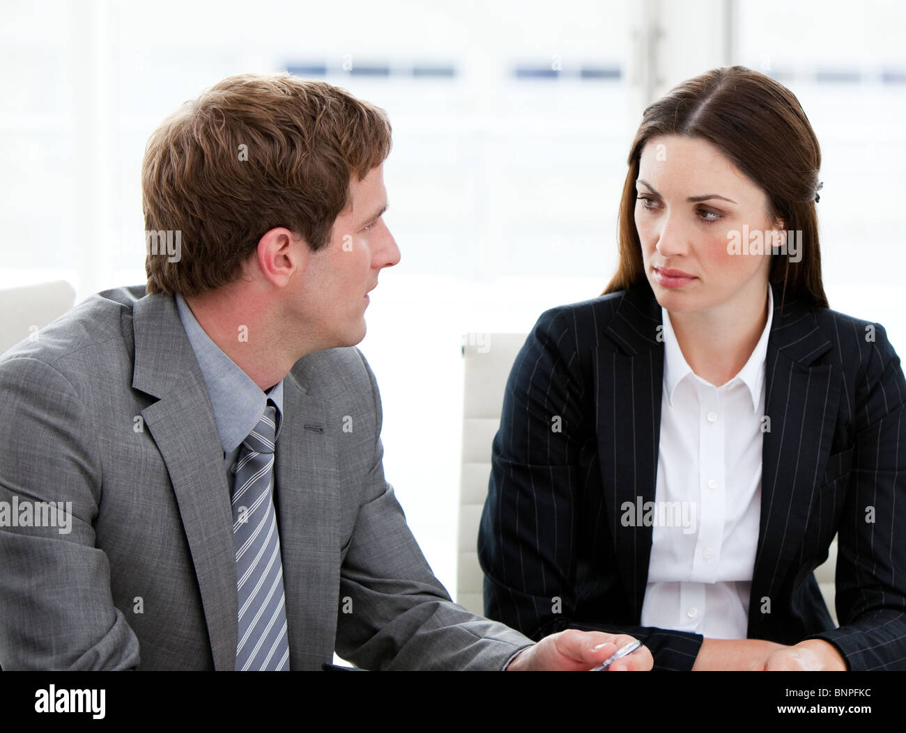 Two concentrated business people talking together Stock Photo - Alamy