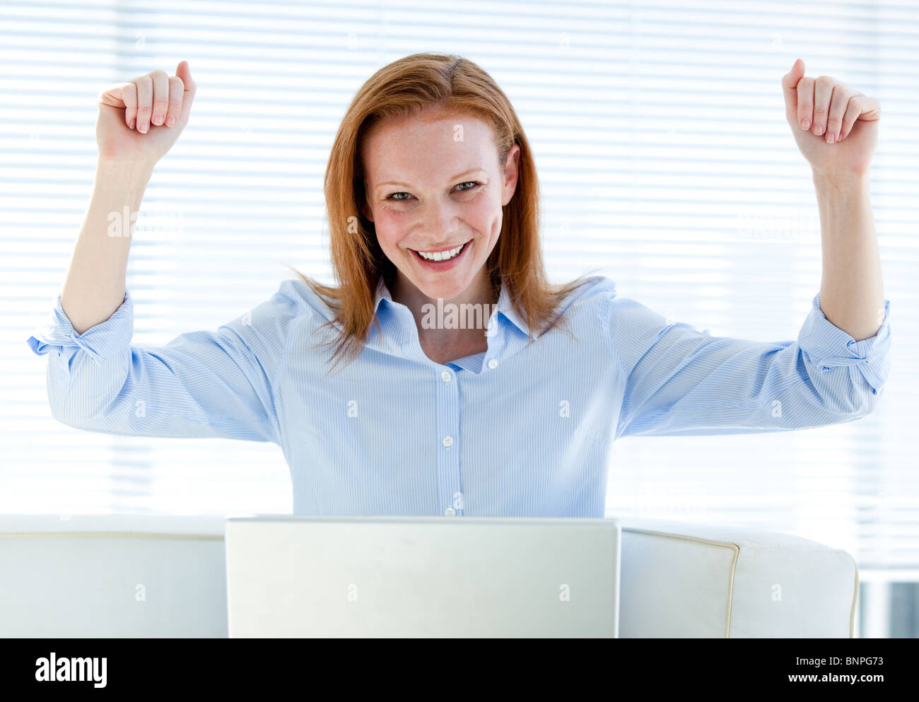 Bright business woman punching the air Stock Photo - Alamy