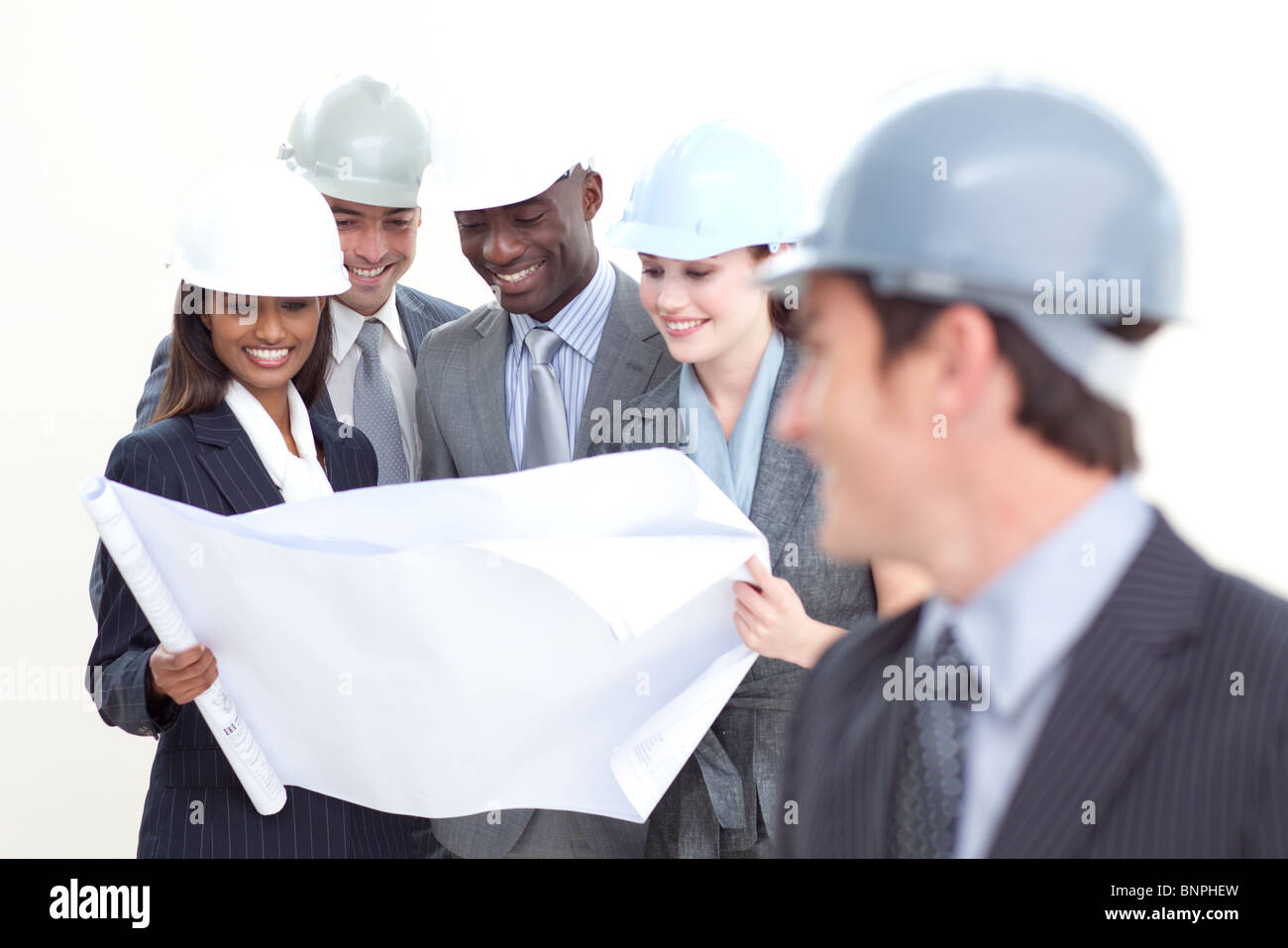 Engineer looking at his team studying a plan Stock Photo - Alamy