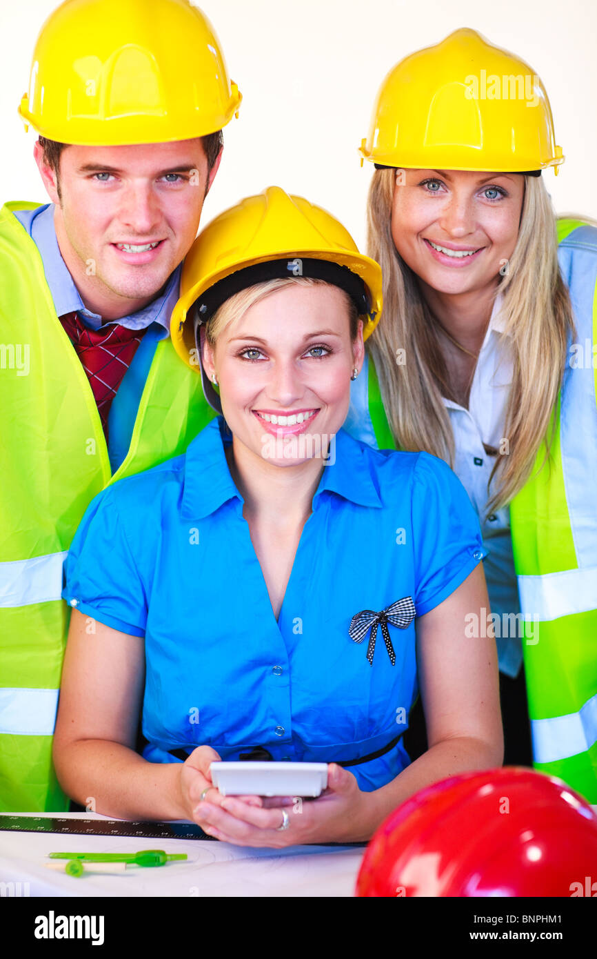 Team of three with hard hats at work smiling at the camera Stock Photo ...