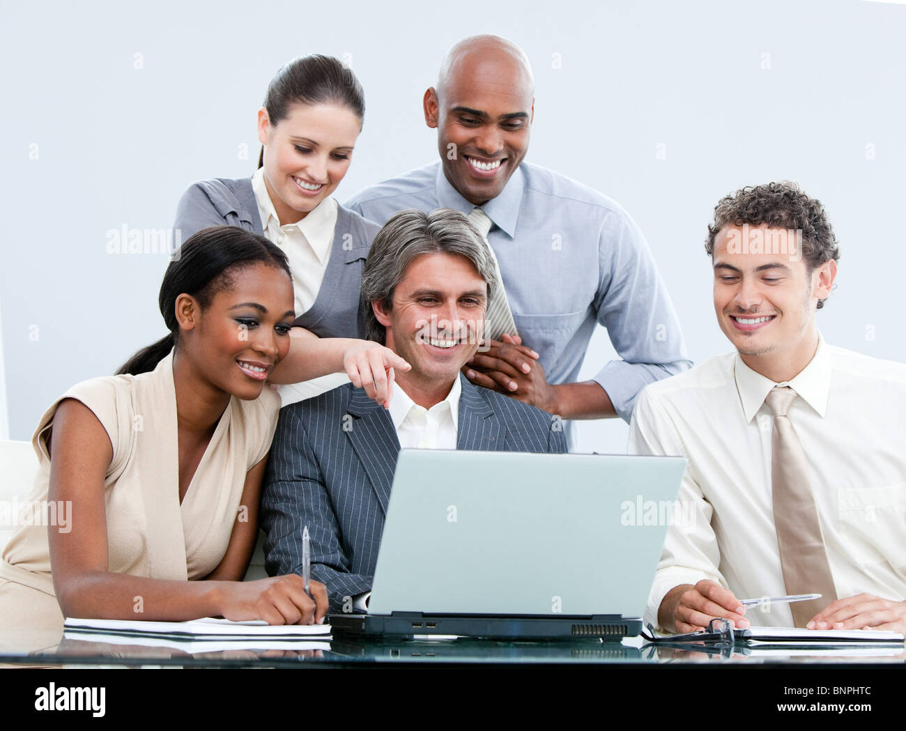 Joyful internationnal Business team looking at the laptop Stock Photo ...