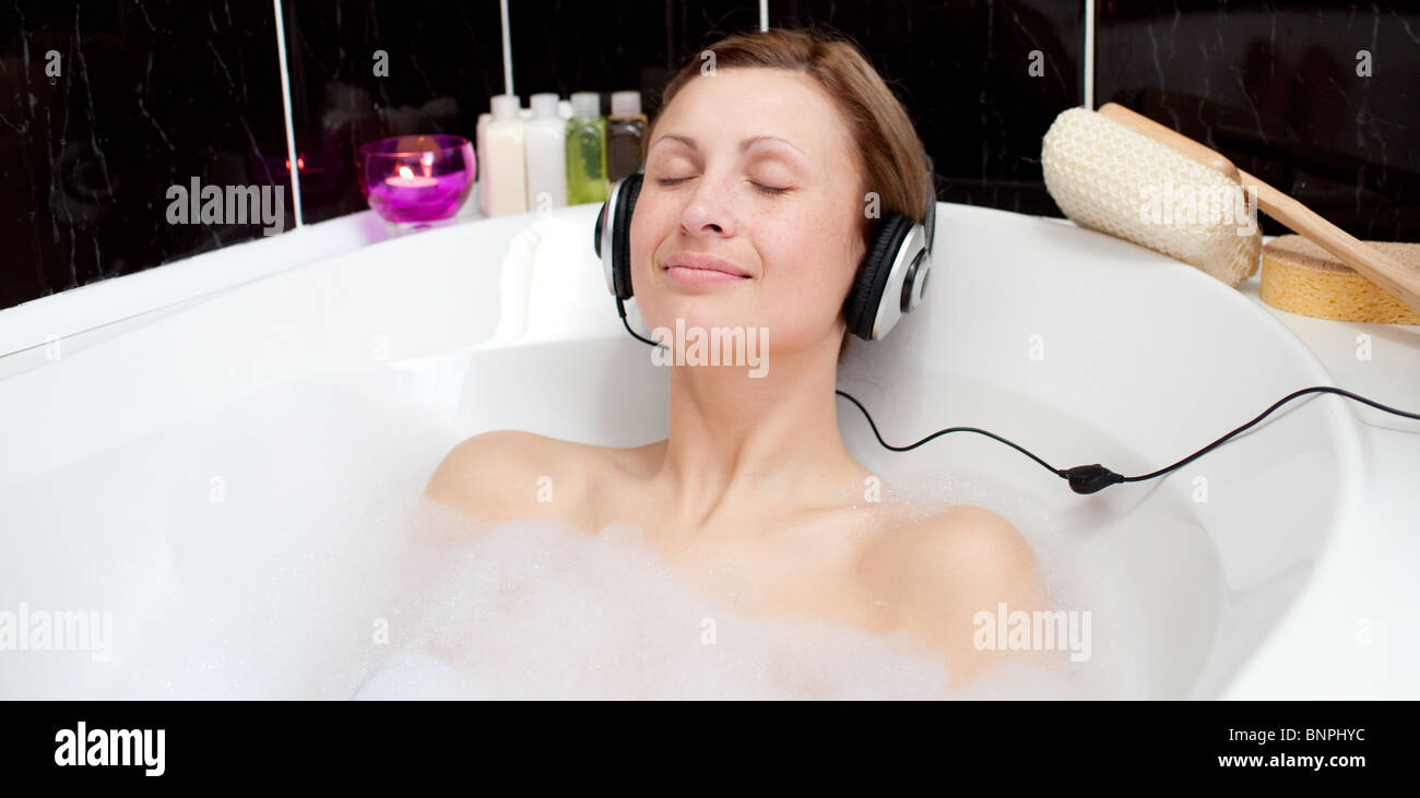 Relaxed woman listening music in a bubble bath Stock Photo - Alamy