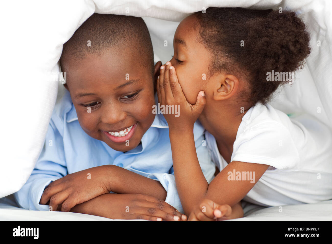 Little girl whispering something to her brother Stock Photo - Alamy