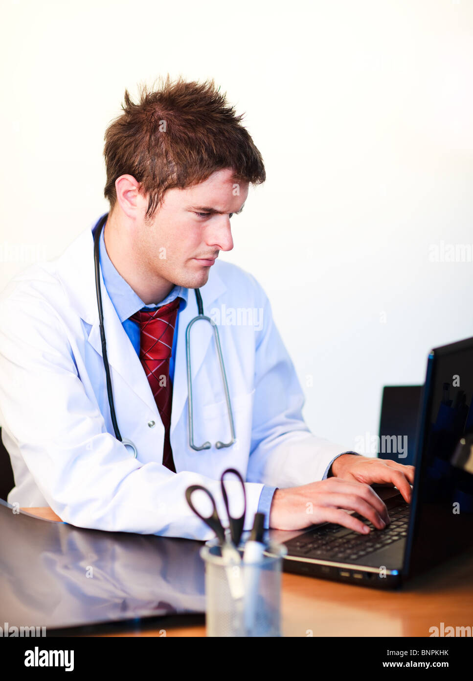 Thoughtful young doctor working on a computer Stock Photo - Alamy